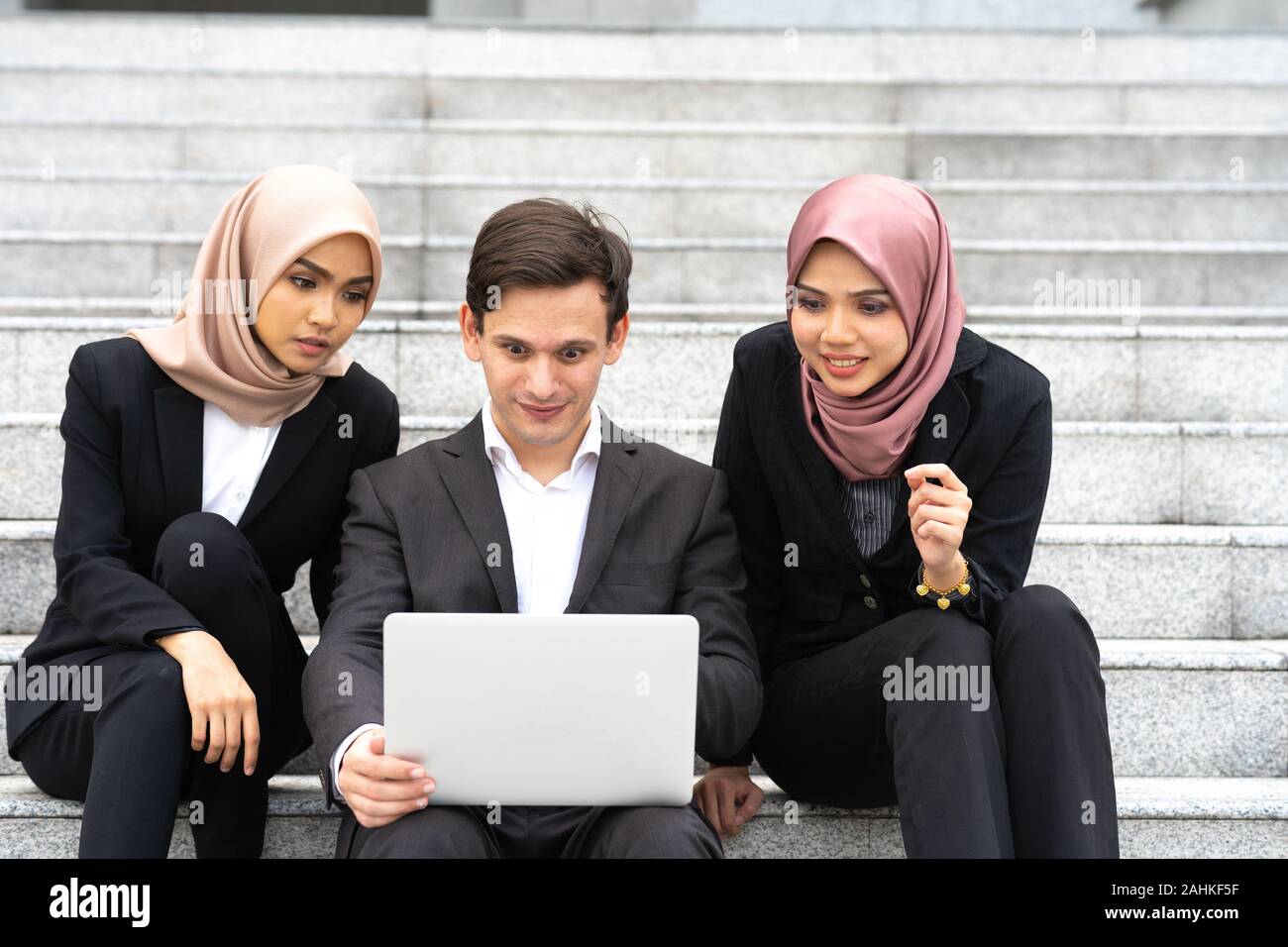 Group of business staff sit at staircase Stock Photo - Alamy