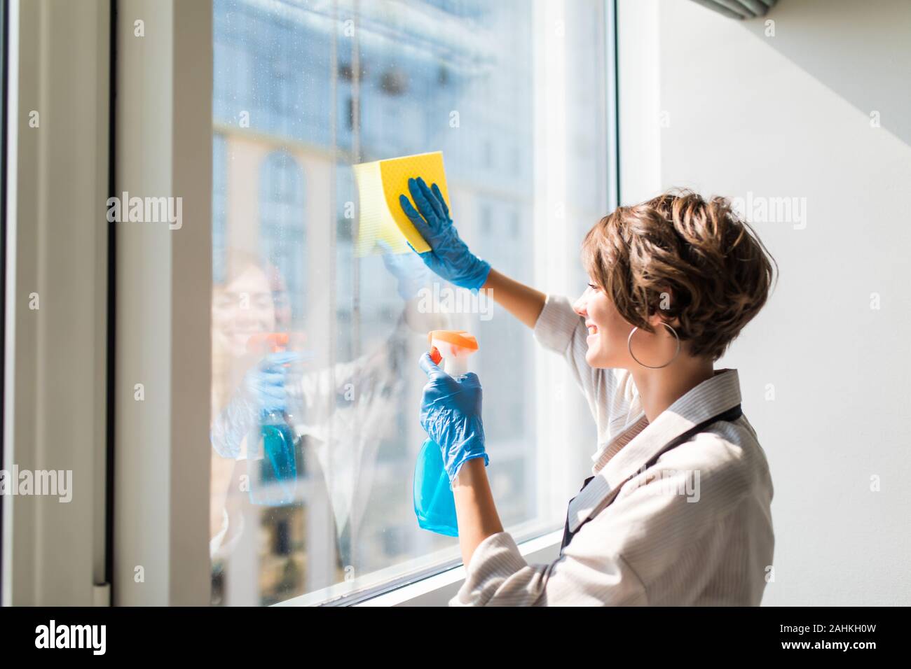 Woman washing window. Housewife cleaning window at home. Housework ...