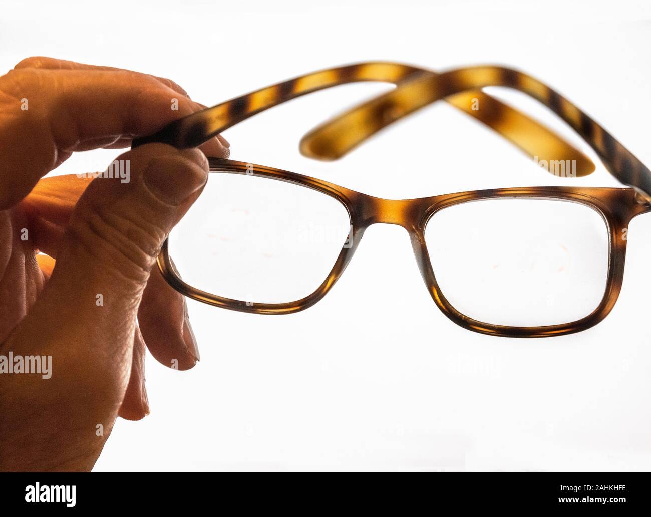 closeup of hand holding eyeglasses Stock Photo - Alamy