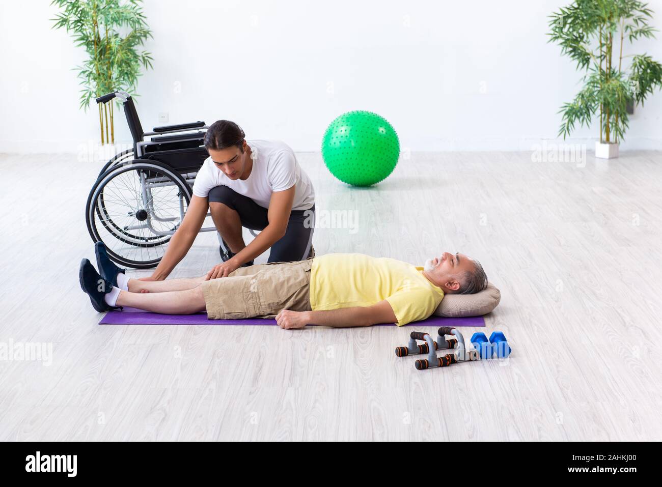 The old injured man doing exercises indoors Stock Photo - Alamy