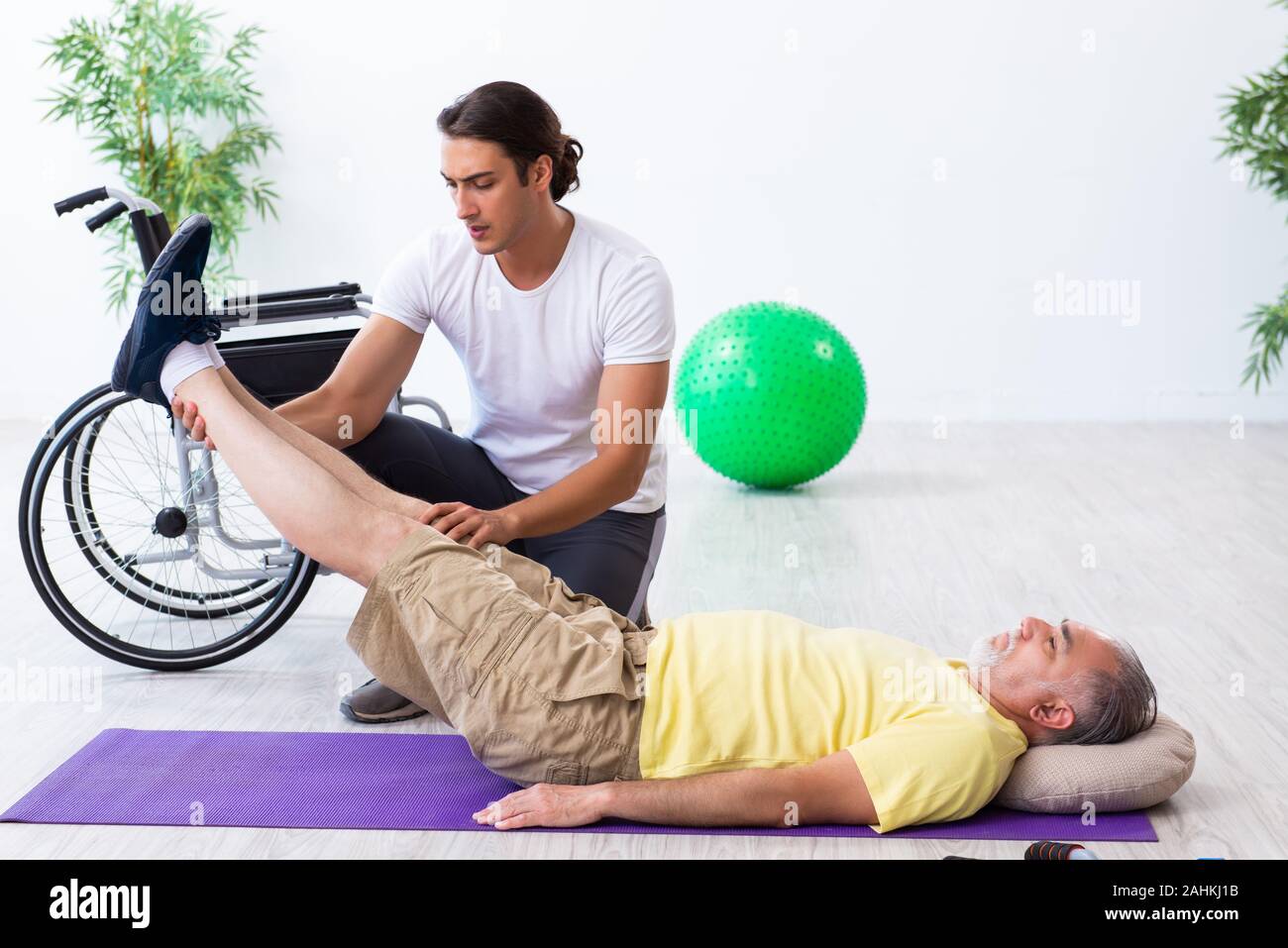 The old injured man doing exercises indoors Stock Photo - Alamy