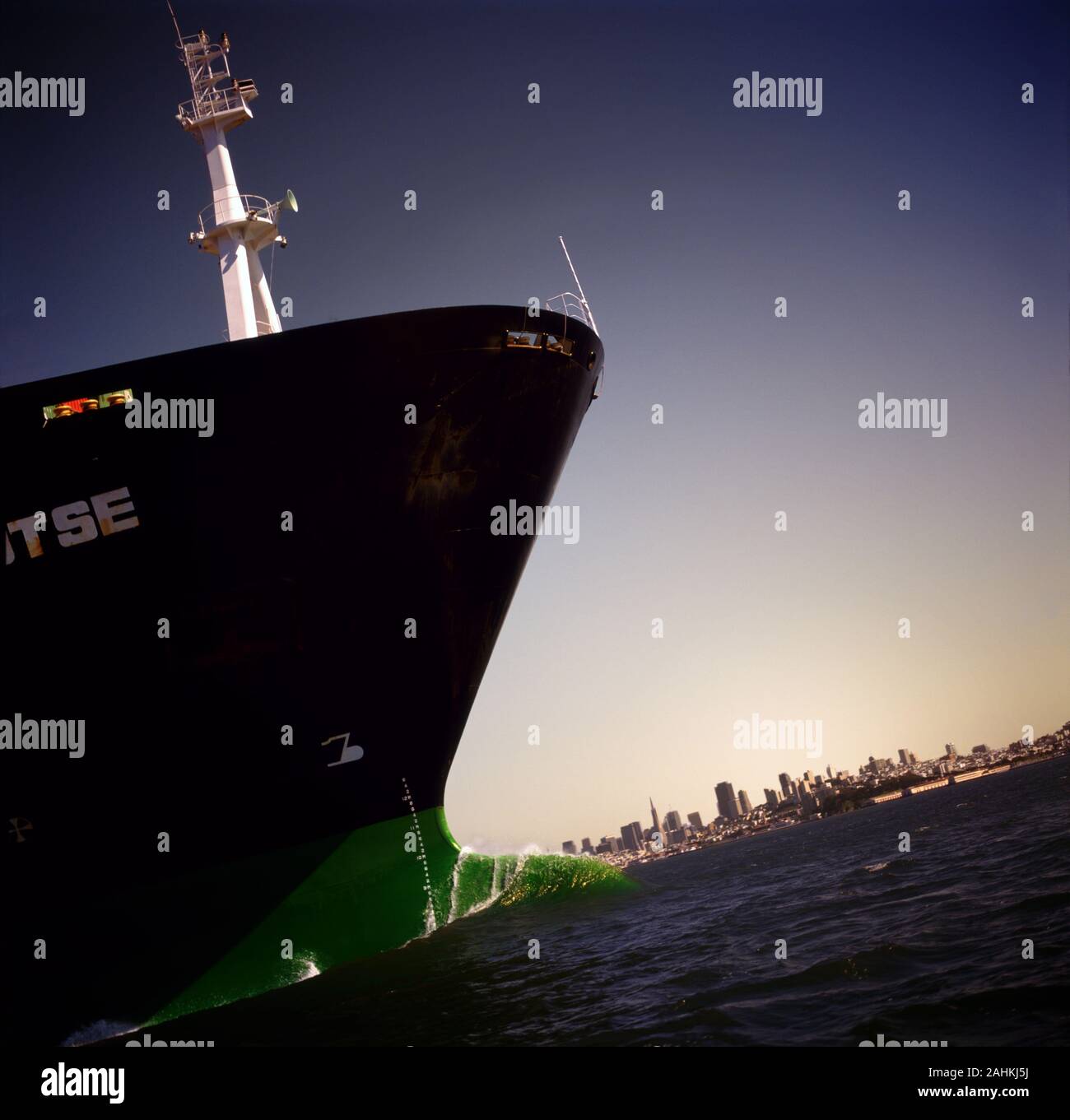 Big ship with city behind it Stock Photo - Alamy