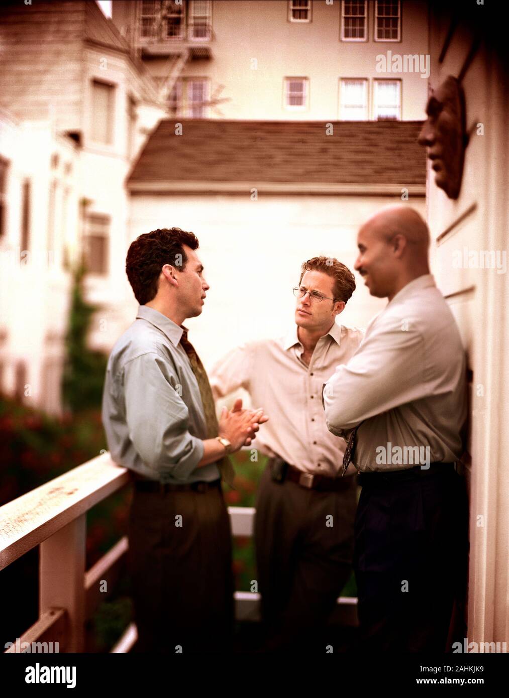 Side view of three men engaged in a discussion Stock Photo - Alamy