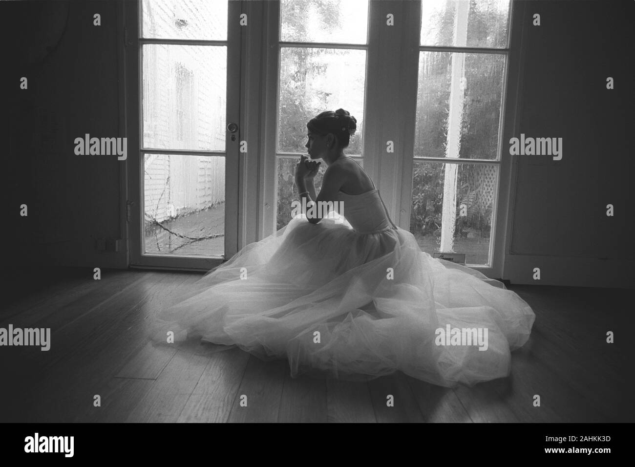 An anxious bride is sitting near a window Stock Photo - Alamy