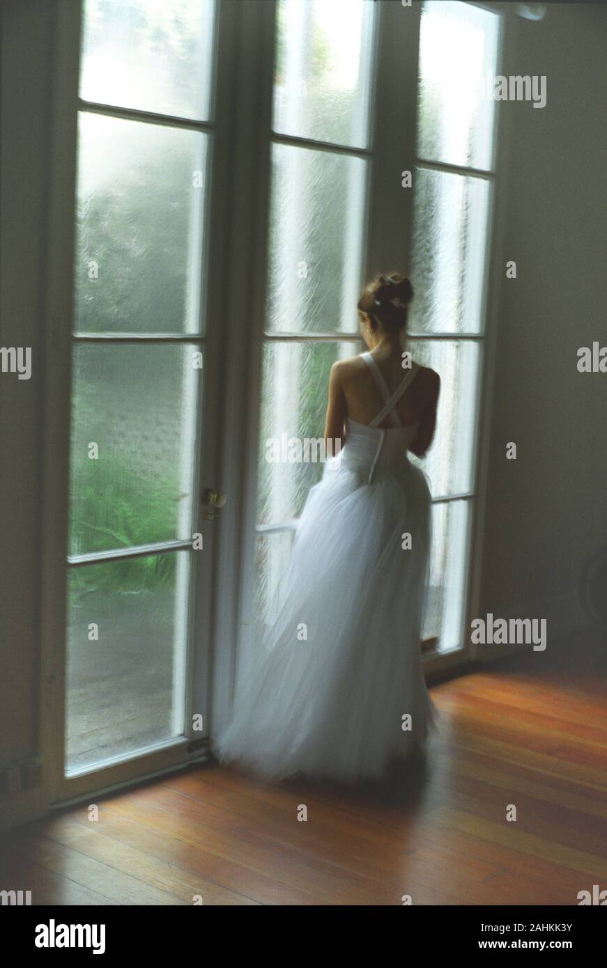 An anxious bride is standing near a window Stock Photo - Alamy
