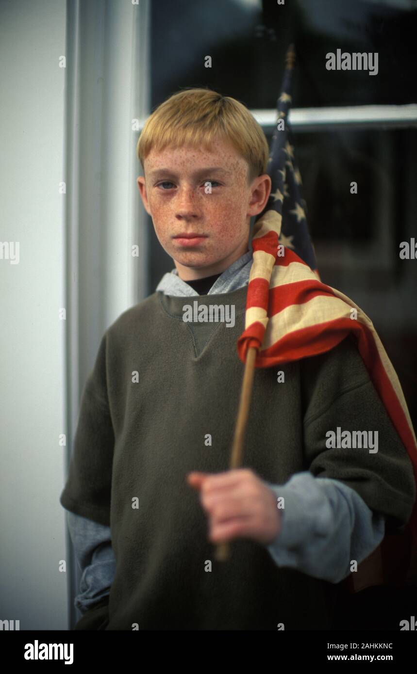 A boy stands with an American flag on his shoulder Stock Photo - Alamy
