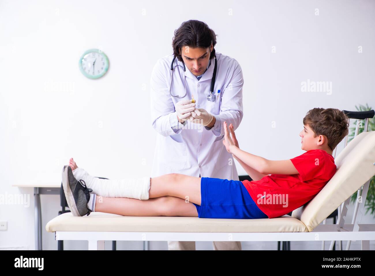 The leg injured boy visiting young doctor traumatologist Stock Photo ...