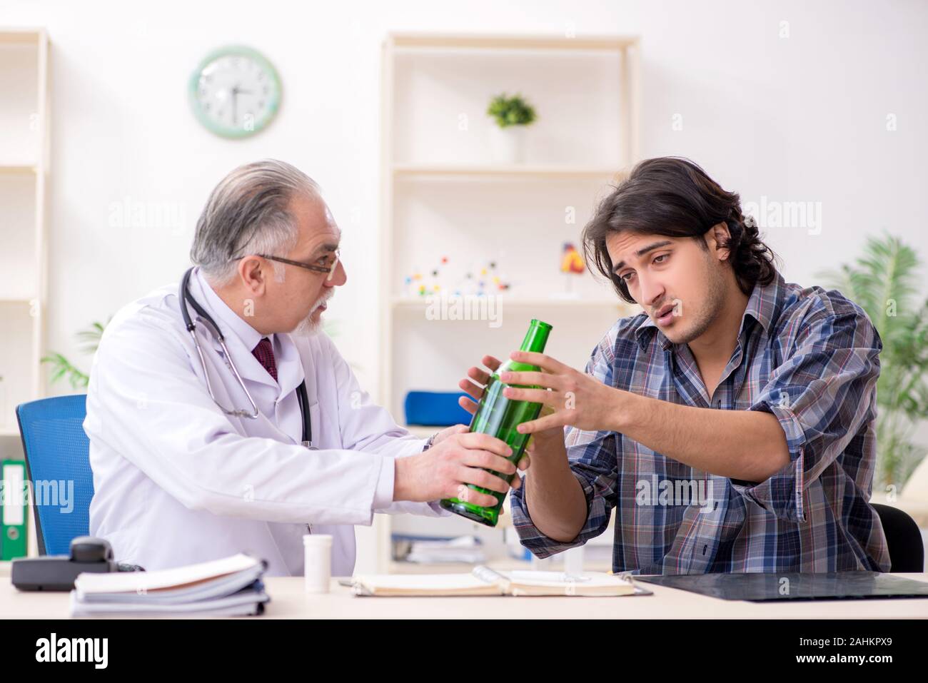 The young male alcoholic visiting old doctor Stock Photo - Alamy