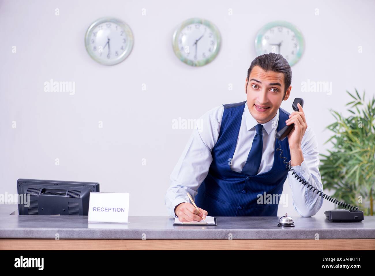 The young man receptionist at the hotel counter Stock Photo - Alamy