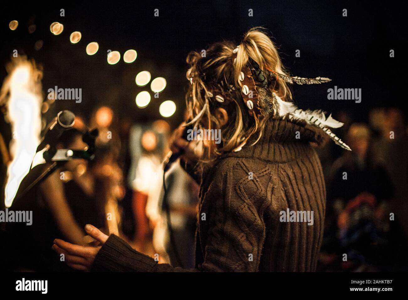 Backside of music performer singing in the night with native ...
