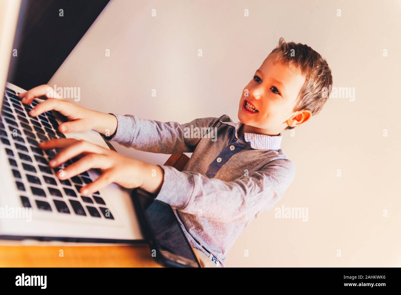 Child using a laptop and laughing at his success in business Stock ...