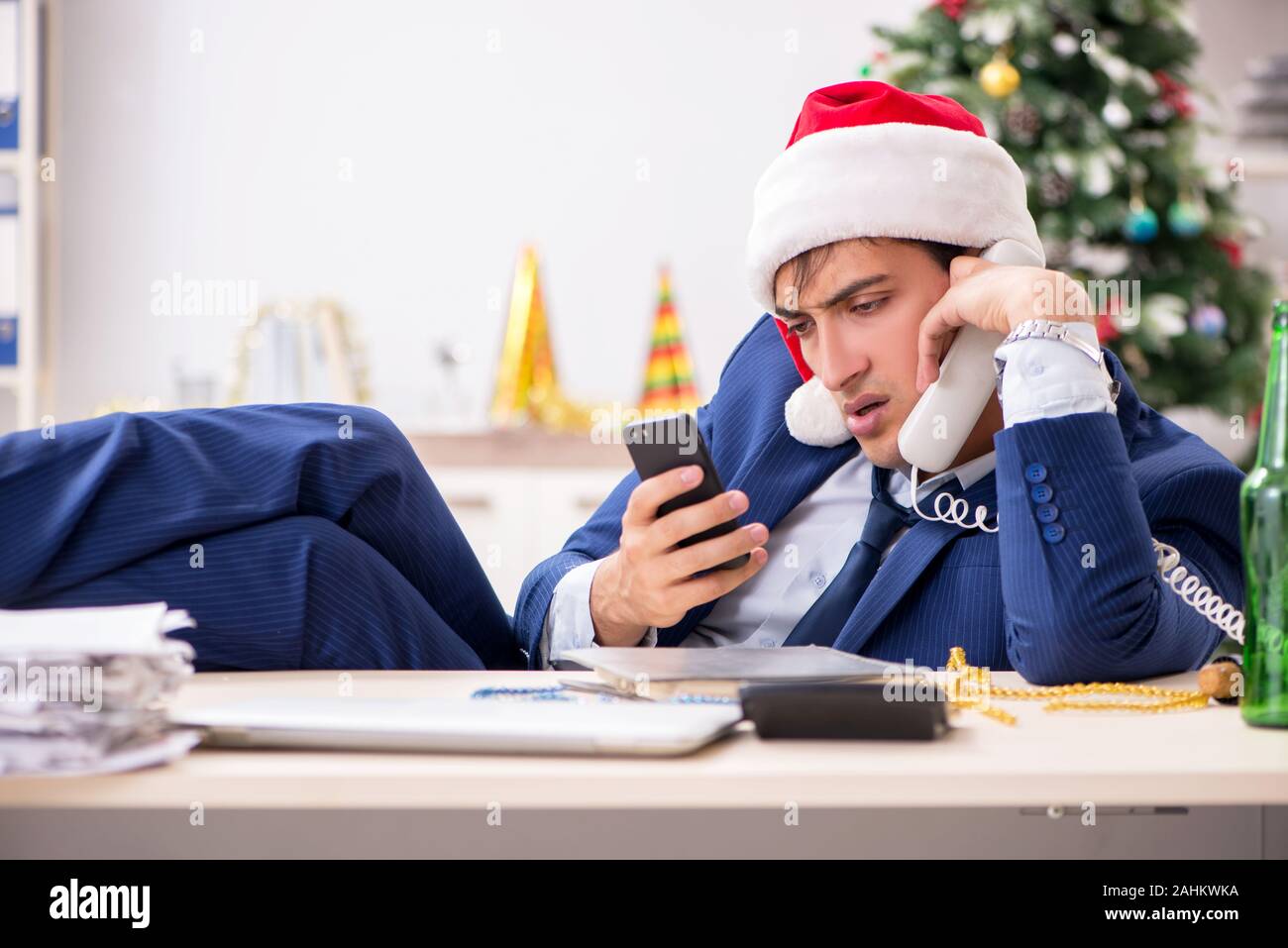 The young handsome employee celebrating christmas at workplace Stock ...