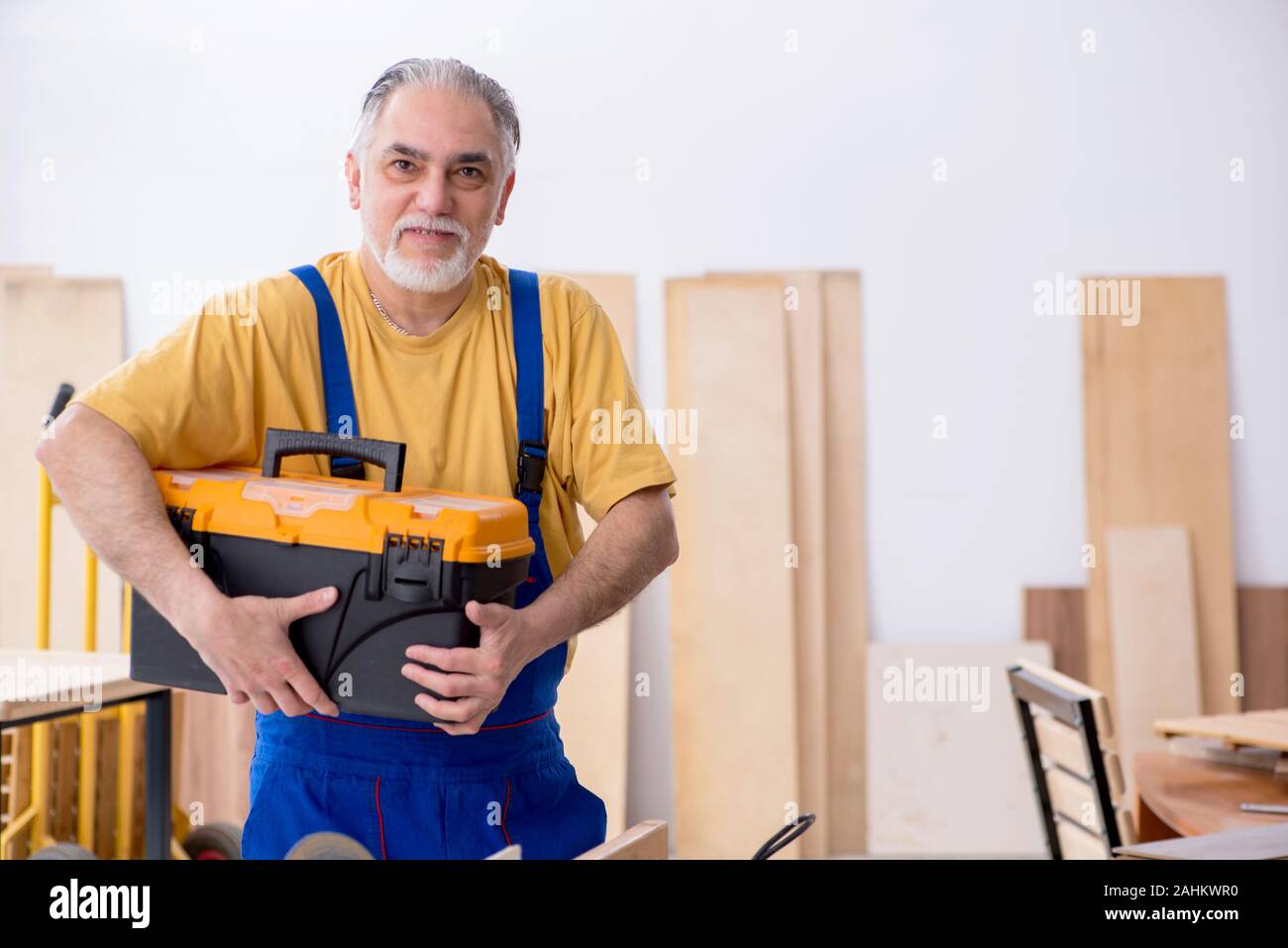 The old male carpenter working in workshop Stock Photo - Alamy