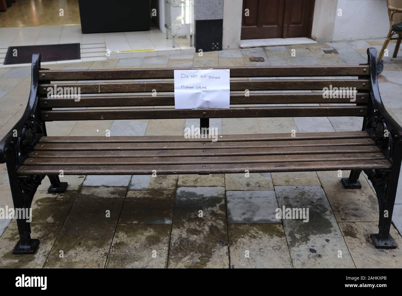 urinated public bench with an alert sign Stock Photo - Alamy