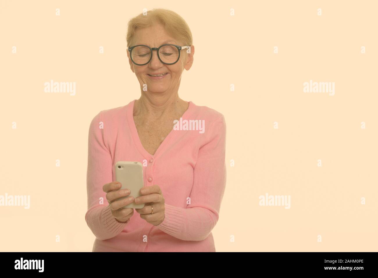 Happy senior nerd woman smiling while using mobile phone Stock Photo ...
