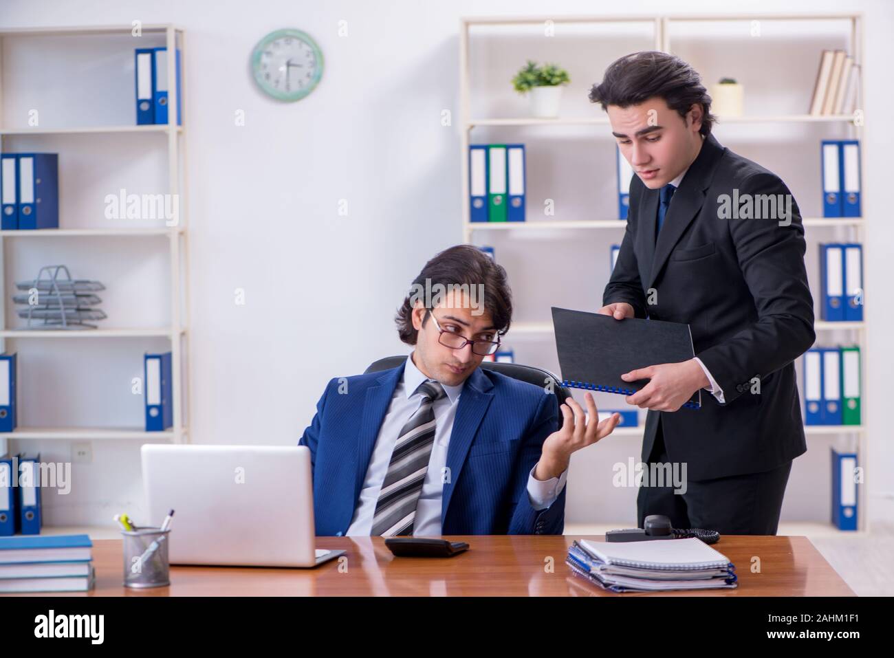 The boss and his male assistant working in the office Stock Photo - Alamy