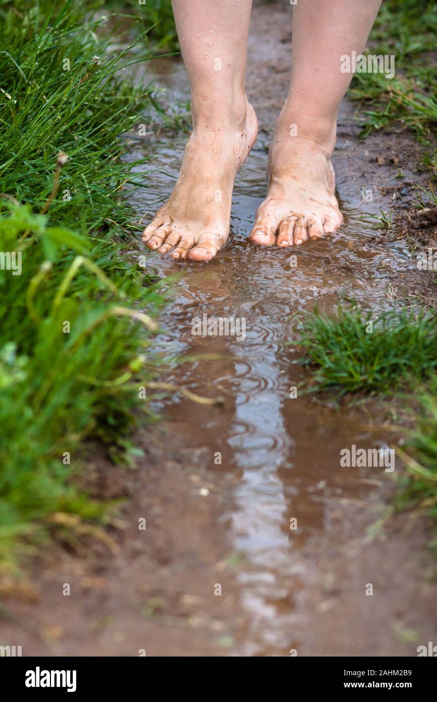 feet of a young woman walking barefoot through the puddles Stock Photo ... feet of a young woman walking barefoot through the puddles Stock Photo ...