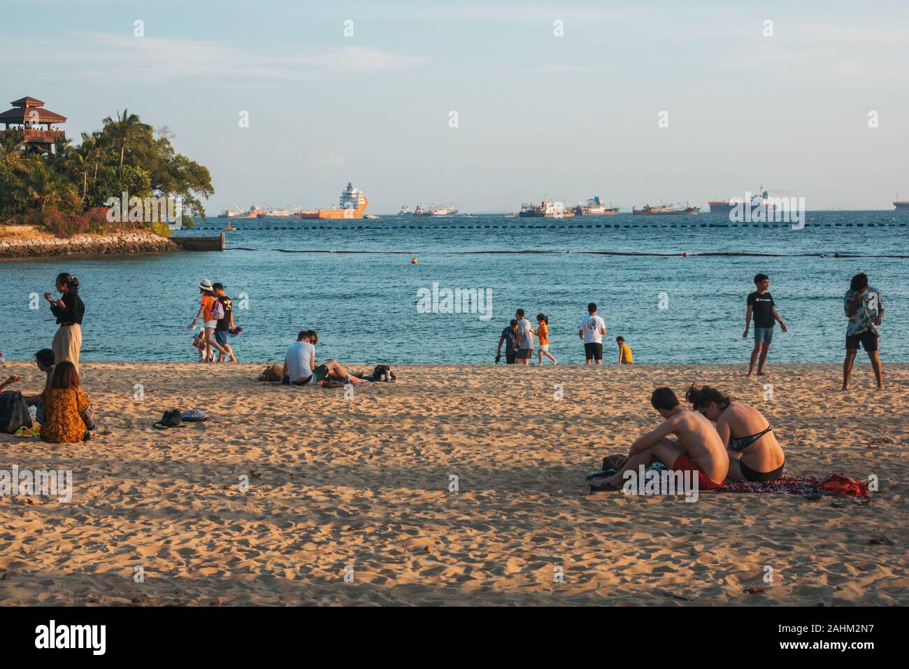 Beachgoers relax in the evening at man-made Palawan Beach, Sentosa ...