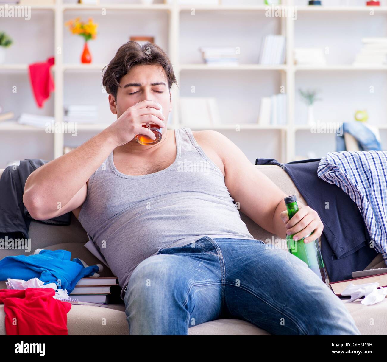The young man student drunk drinking alcohol in a messy room Stock ...