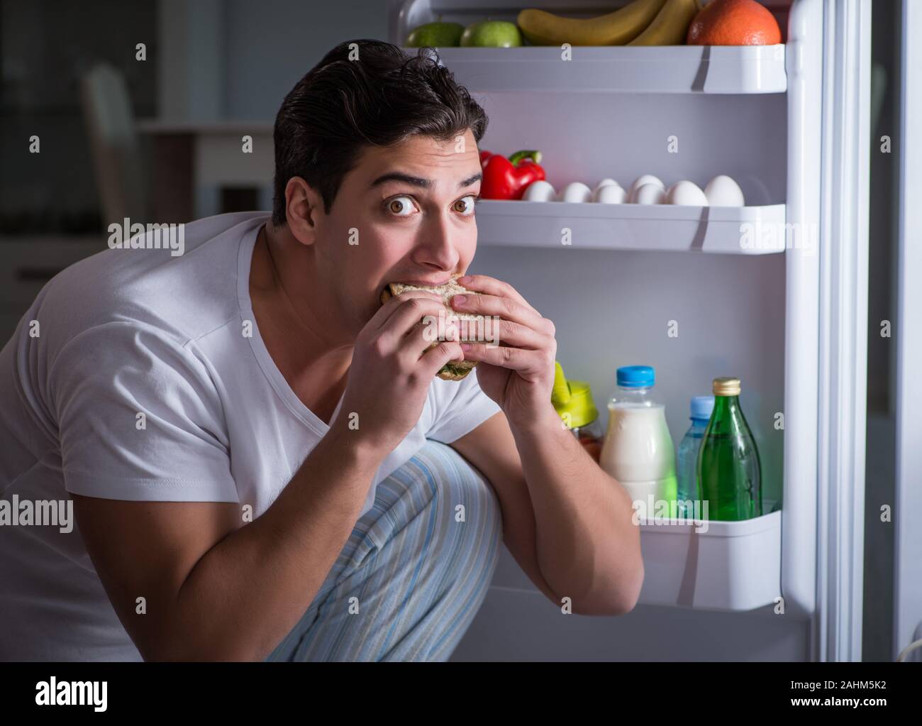 Man opening refrigerator at night hi-res stock photography and images ...
