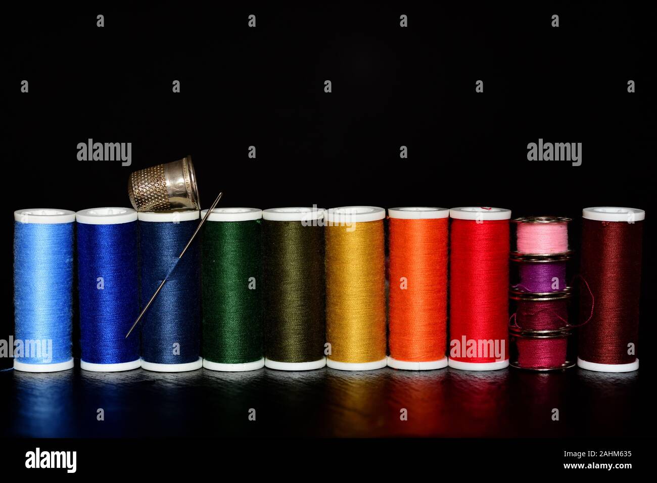 Still life of different rolls of sewing thread in rainbow colors, with ...