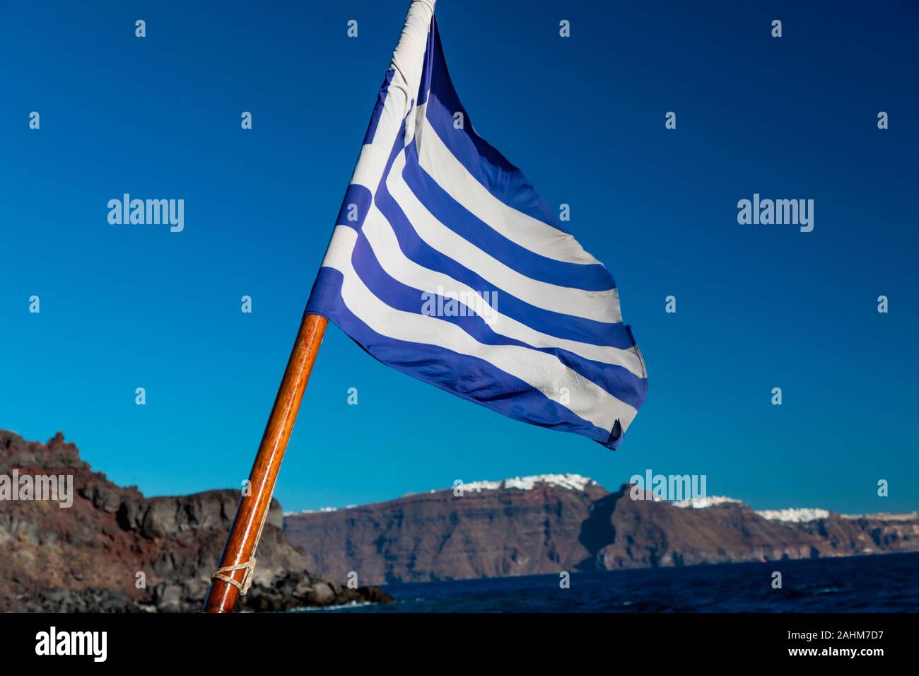 The Greek flag fluttering in the wind off the back of a sail boat in ...