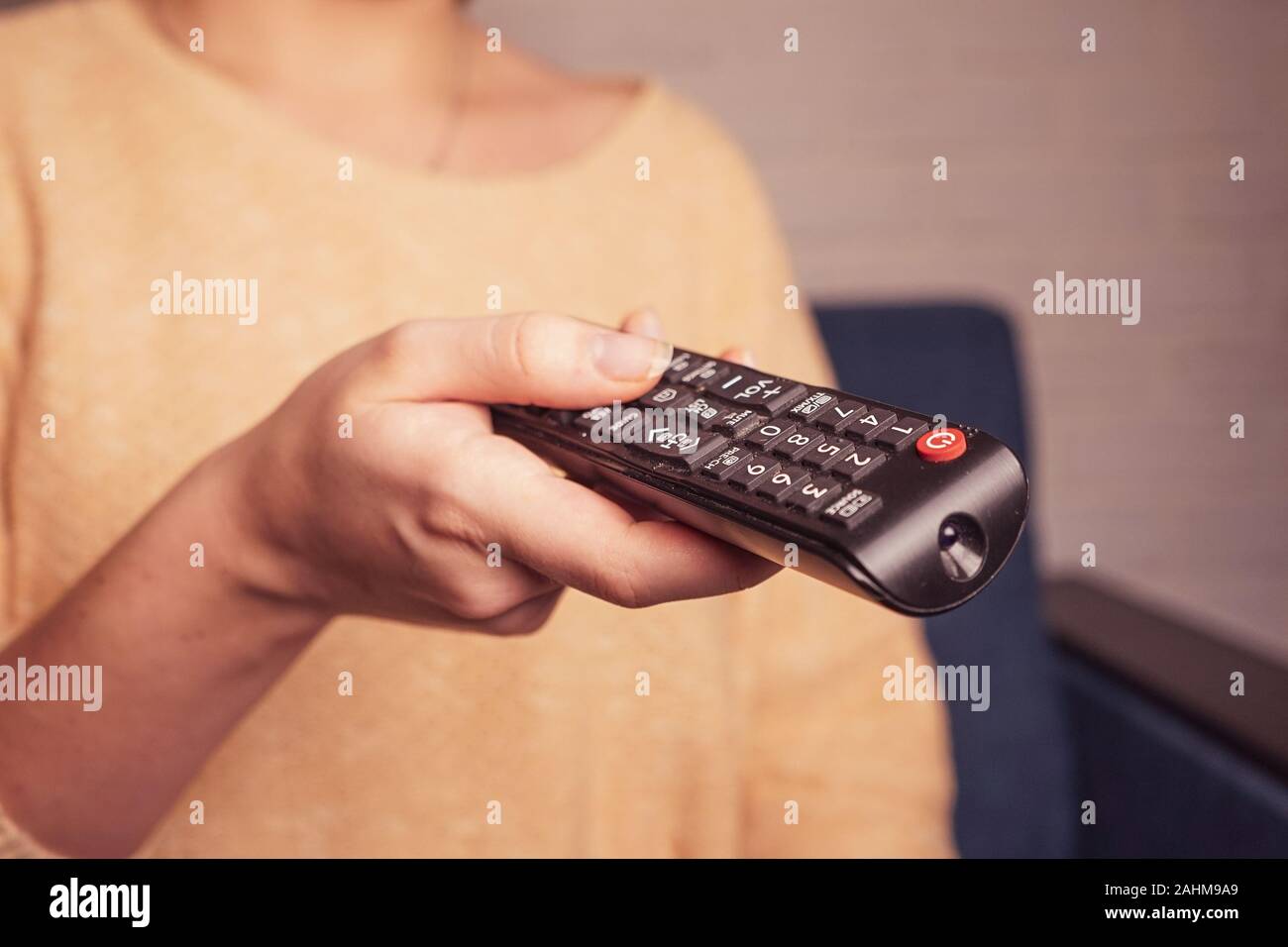 a girl holding in her hands a remote control from the TV Stock Photo ...