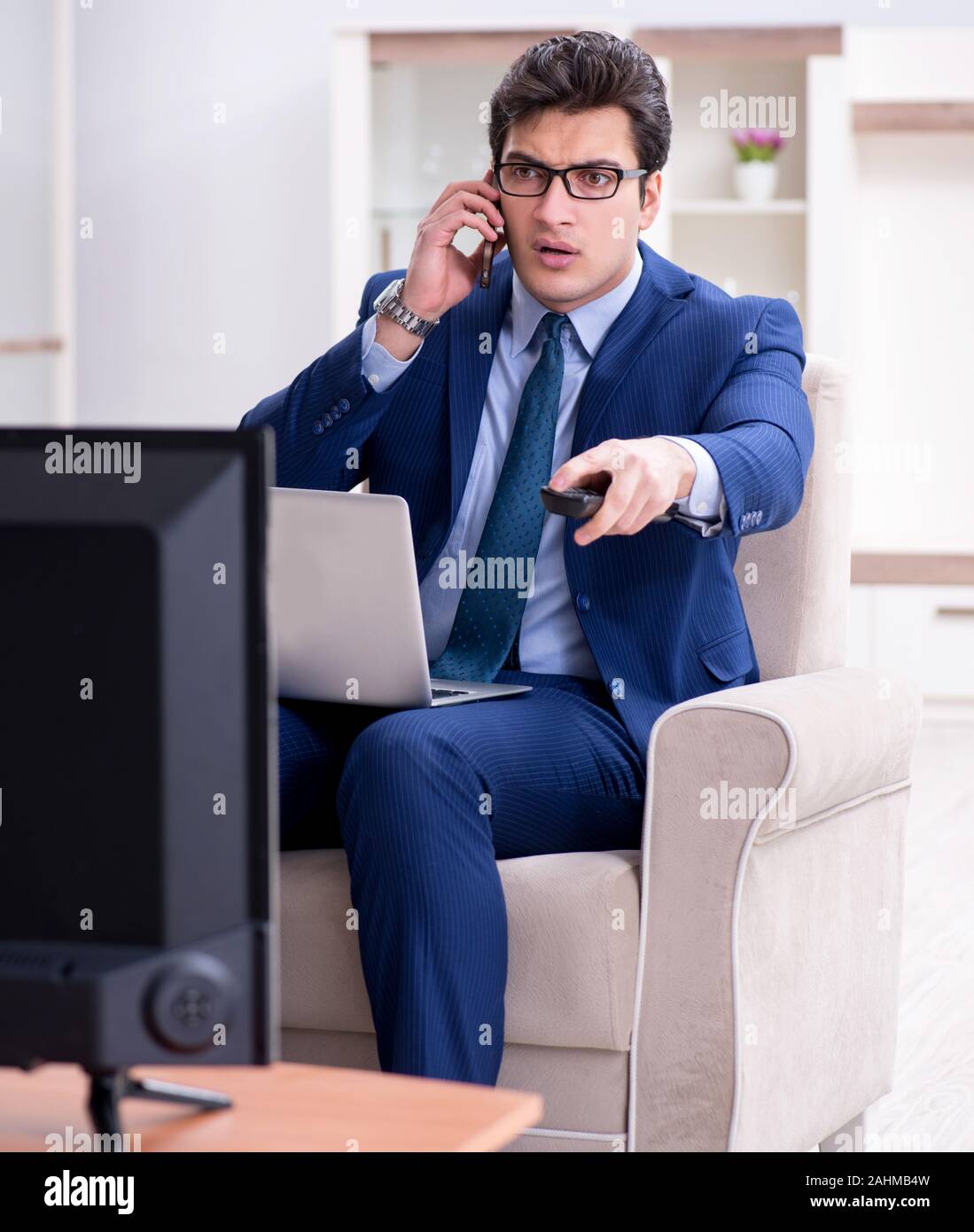 The businessman watching tv in the office Stock Photo - Alamy