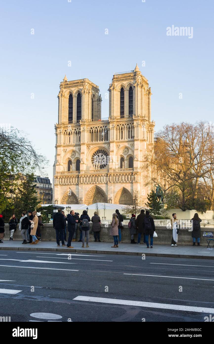 Tourists on stone bridge taking photographs of Notre-Dame cathedral ...
