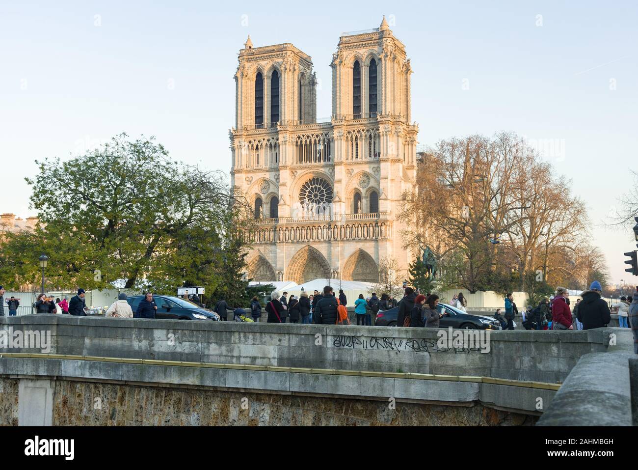Tourists on stone bridge taking photographs of Notre-Dame cathedral ...