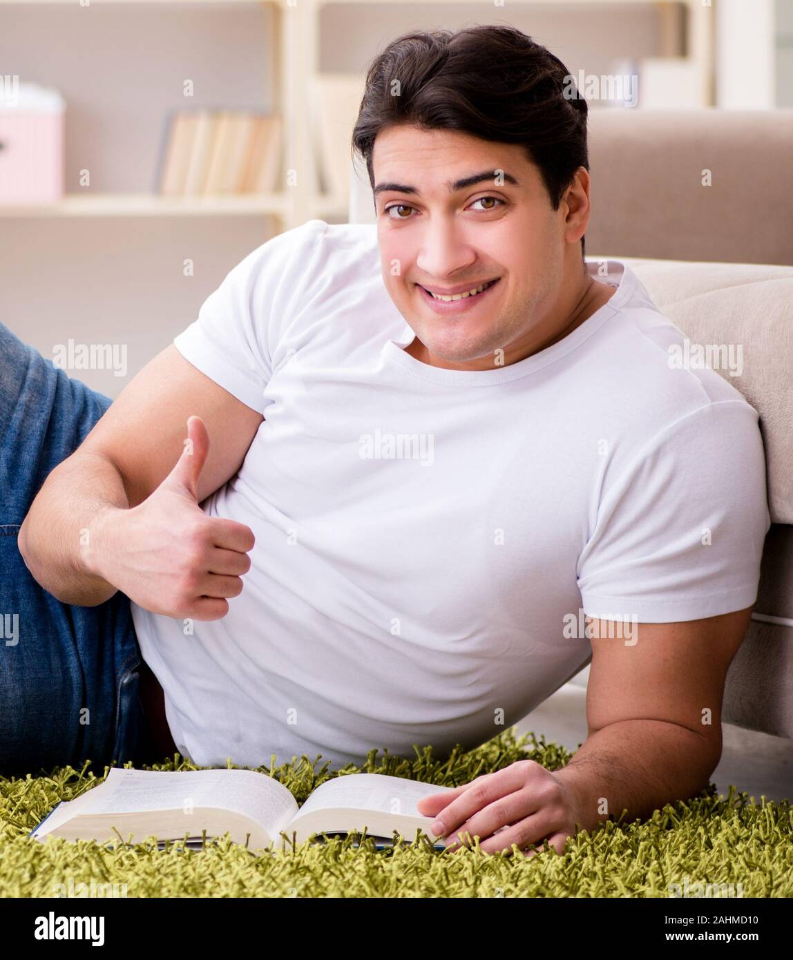 The man reading book at home on floor Stock Photo - Alamy