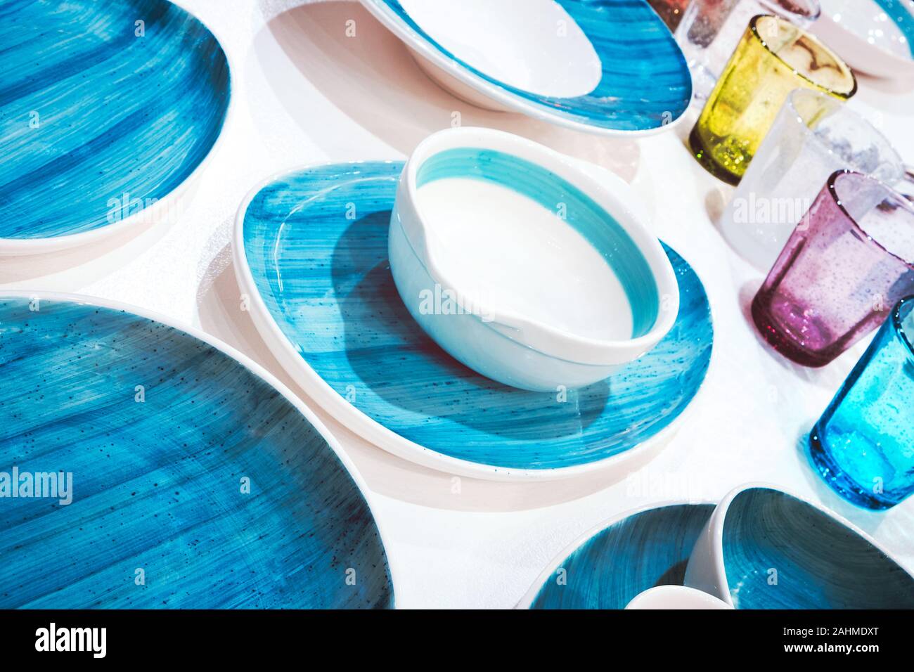 multi-colored dishes utensils on a white background Stock Photo - Alamy