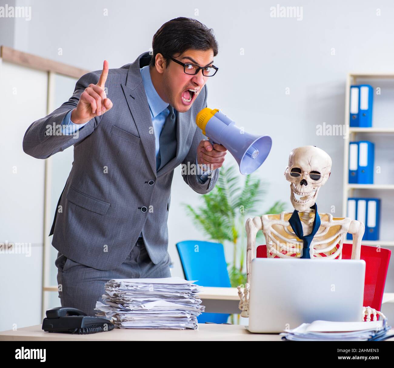 The angry boss yelling at his skeleton employee Stock Photo - Alamy