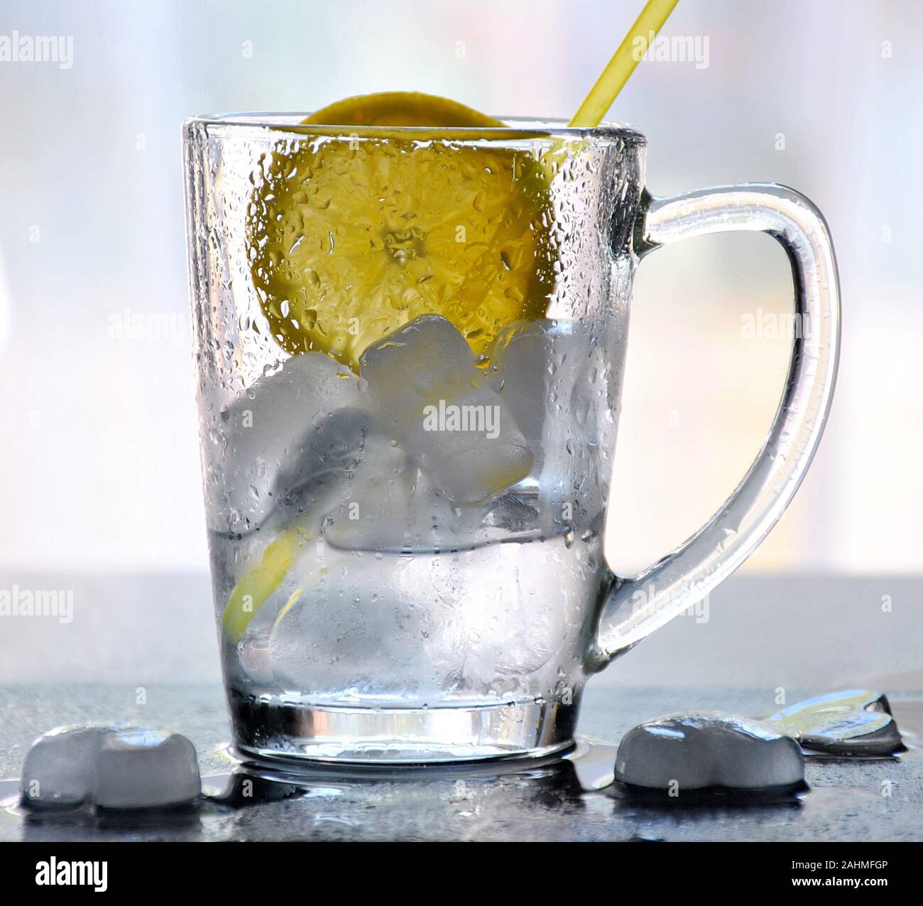 Cold water with lemon and ice cubes Stock Photo - Alamy
