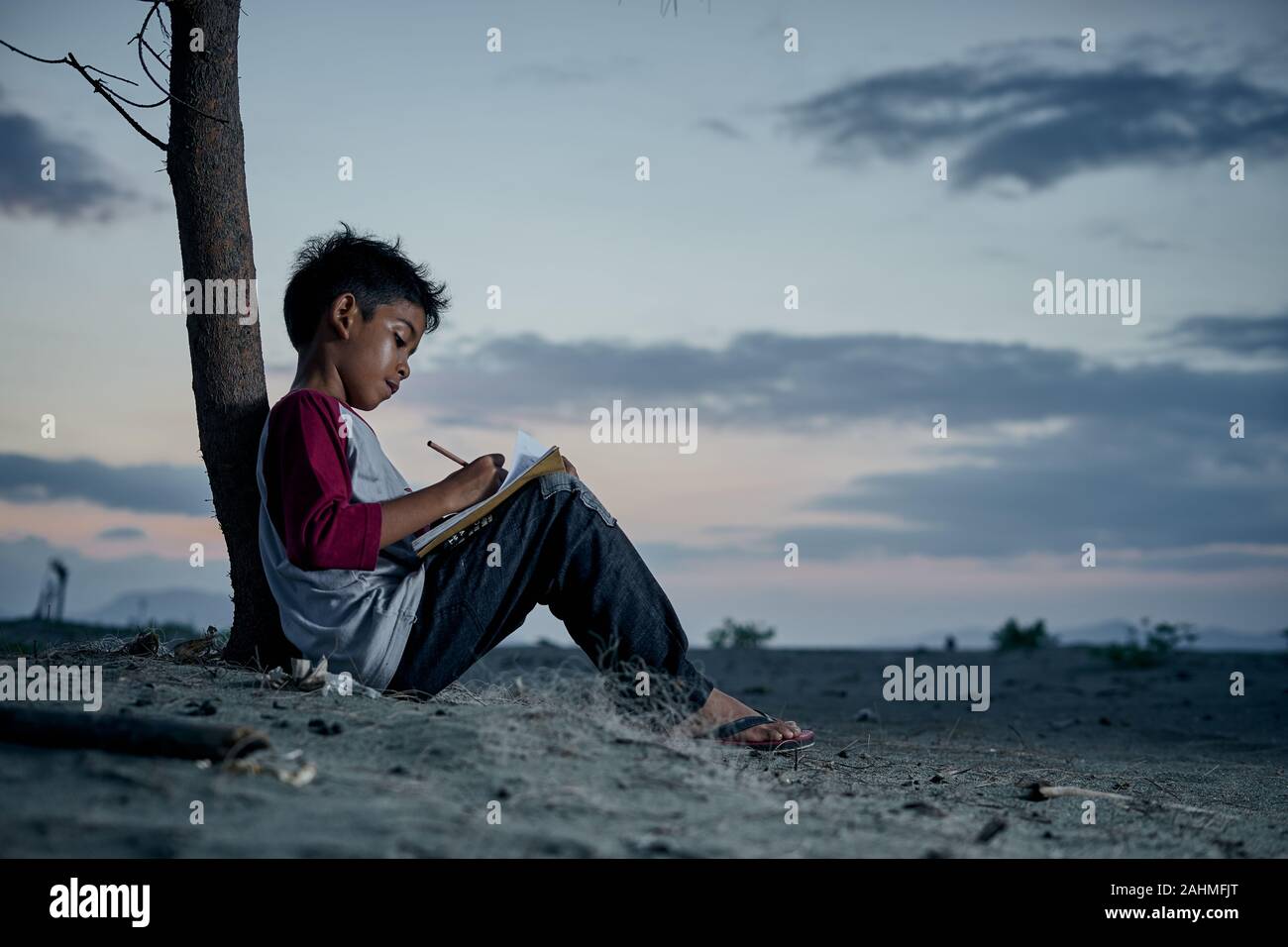 Smart boy doing homework outdoor under the sky at night Stock Photo - Alamy