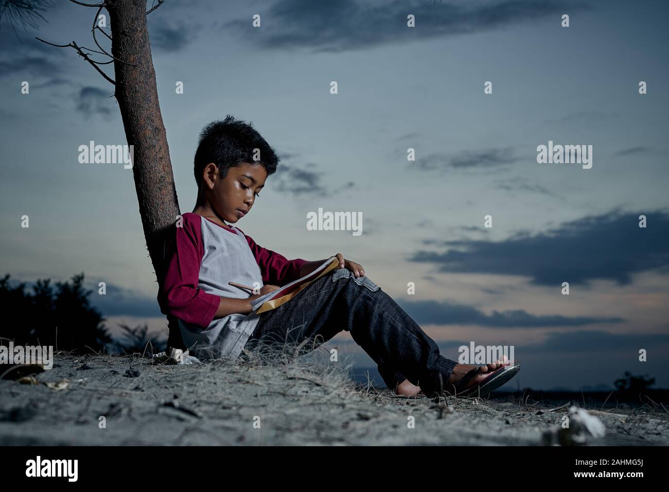 Smart boy doing homework outdoor under the sky at night Stock Photo - Alamy