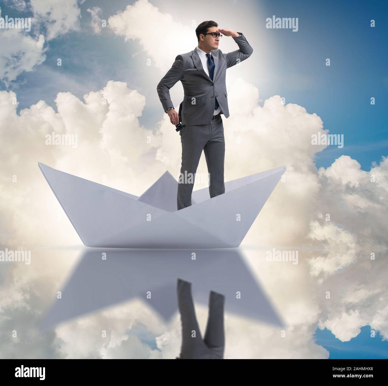Businessman looking into future with binoculars in paper ship boat ...