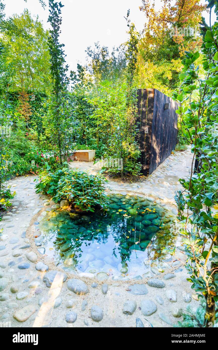 Garden design with a small round pond iwht boulders Stock Photo - Alamy
