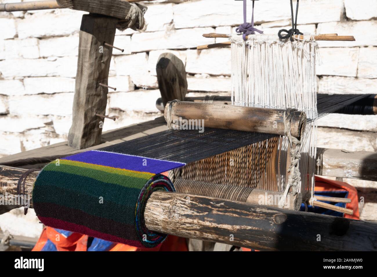 A loom setting outdoors with some very colorful cloth in it Stock Photo ...