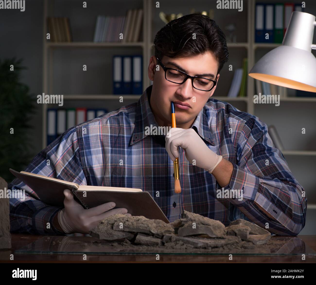The archeologist working late night in office Stock Photo - Alamy