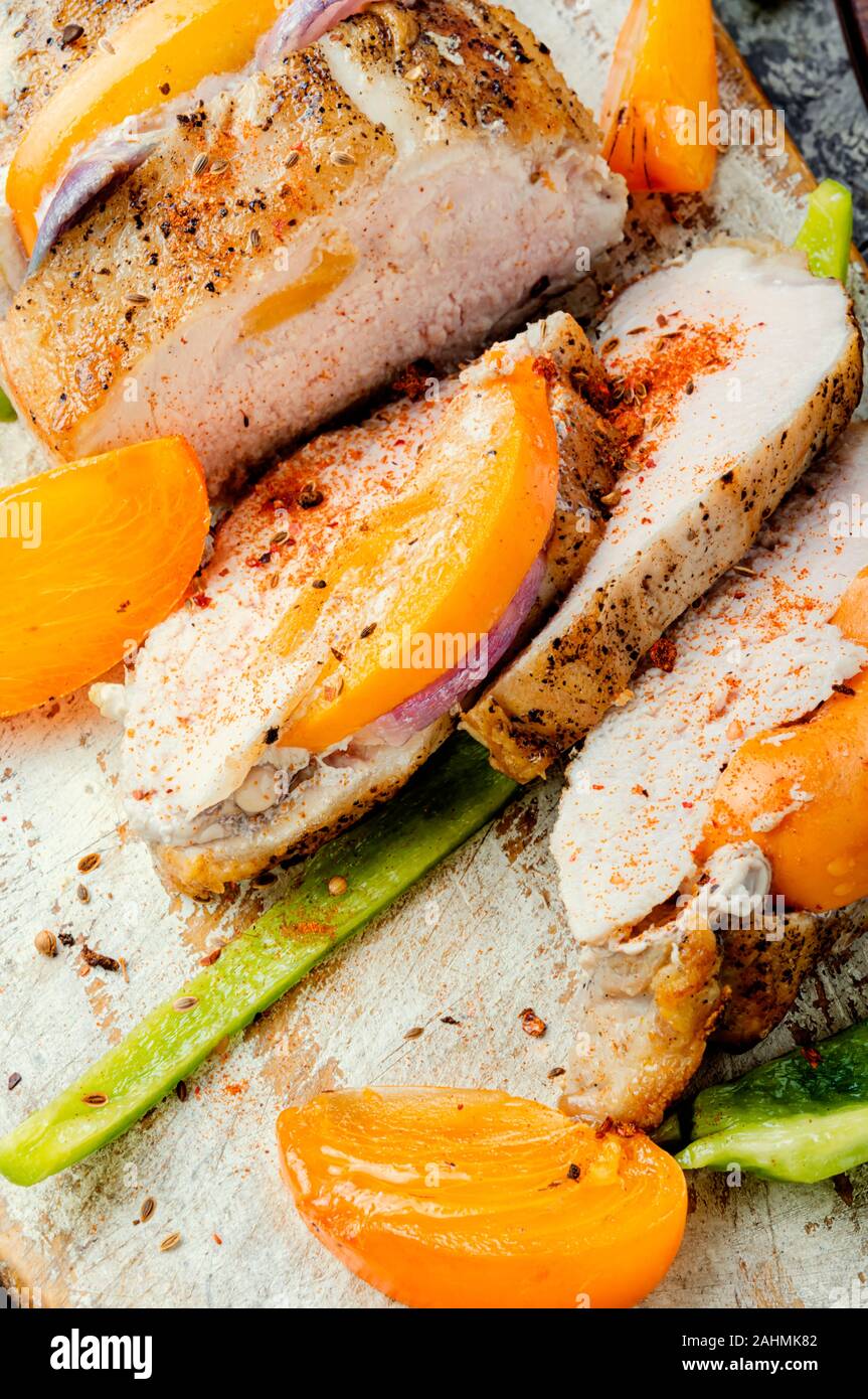 Roasted of pork with persimmon on cutting board.Holiday food.Closeup ...