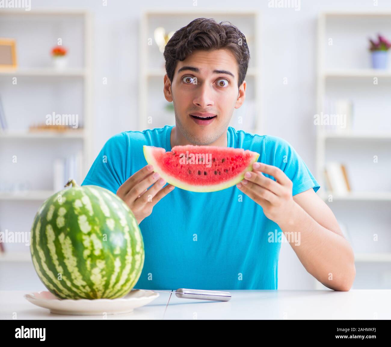 The man eating watermelon at home Stock Photo - Alamy