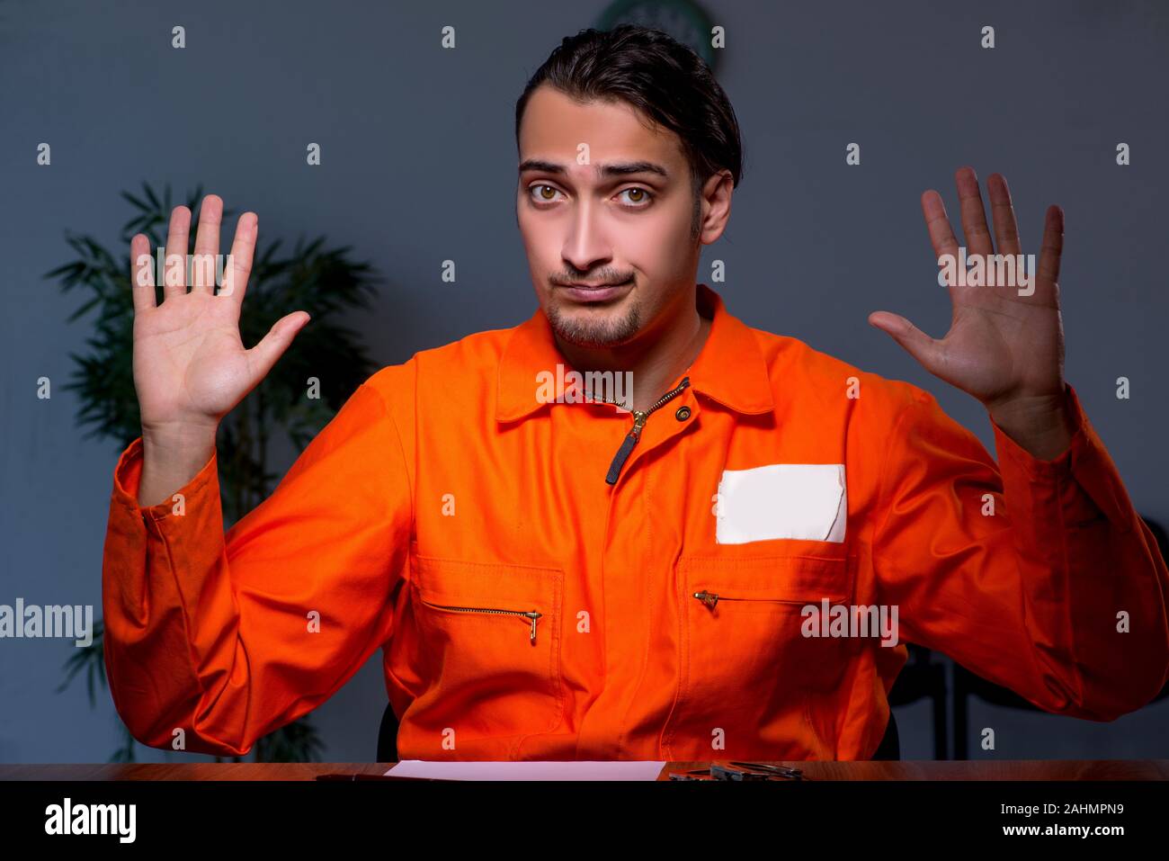 The young convict man sitting in dark room Stock Photo - Alamy