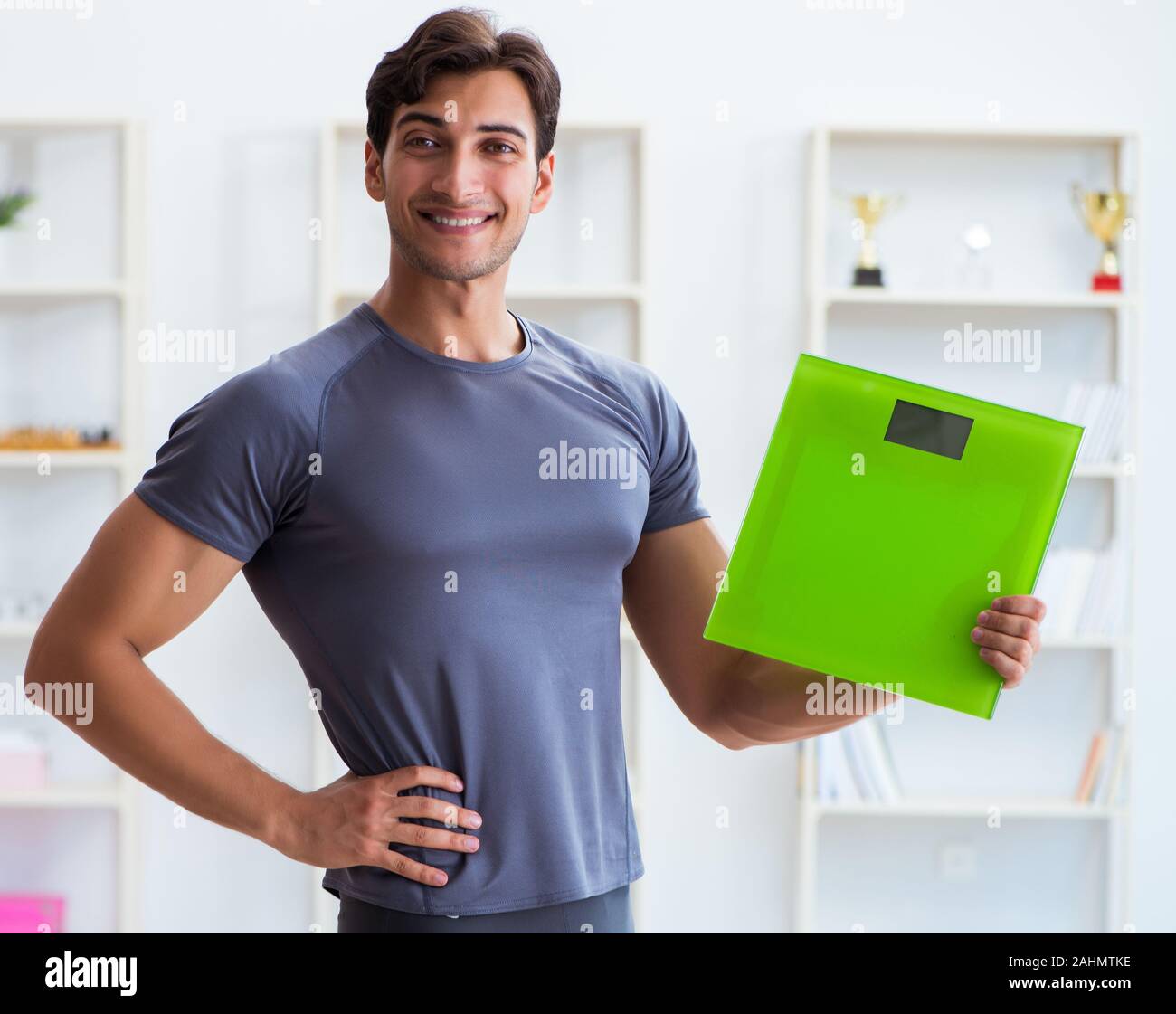 The man with scales in sports and health concept Stock Photo - Alamy