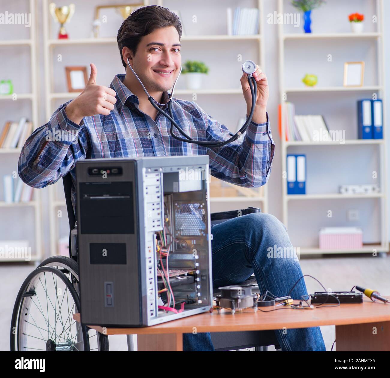 The disabled man on wheelchair repairing computer Stock Photo - Alamy