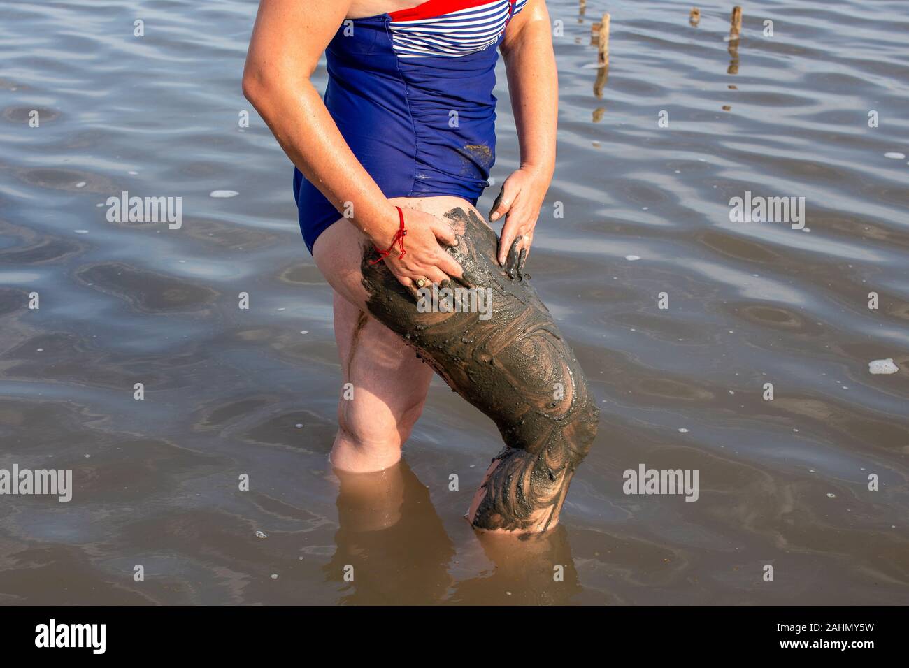 Woman applying on her leg body salty healing mud in lake Stock Photo ...