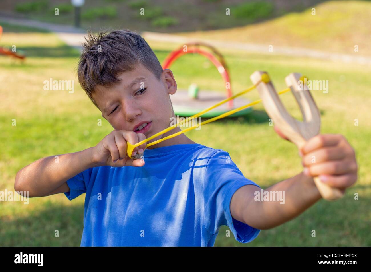 Little boy shooting with slingshot at playground outdoors Stock Photo ...