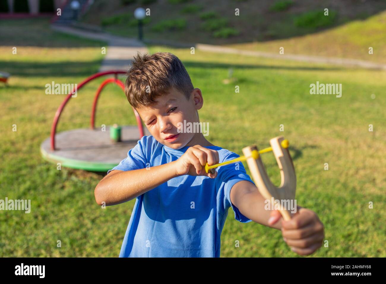 Little kid shooting with slingshot at playground outdoors Stock Photo ...
