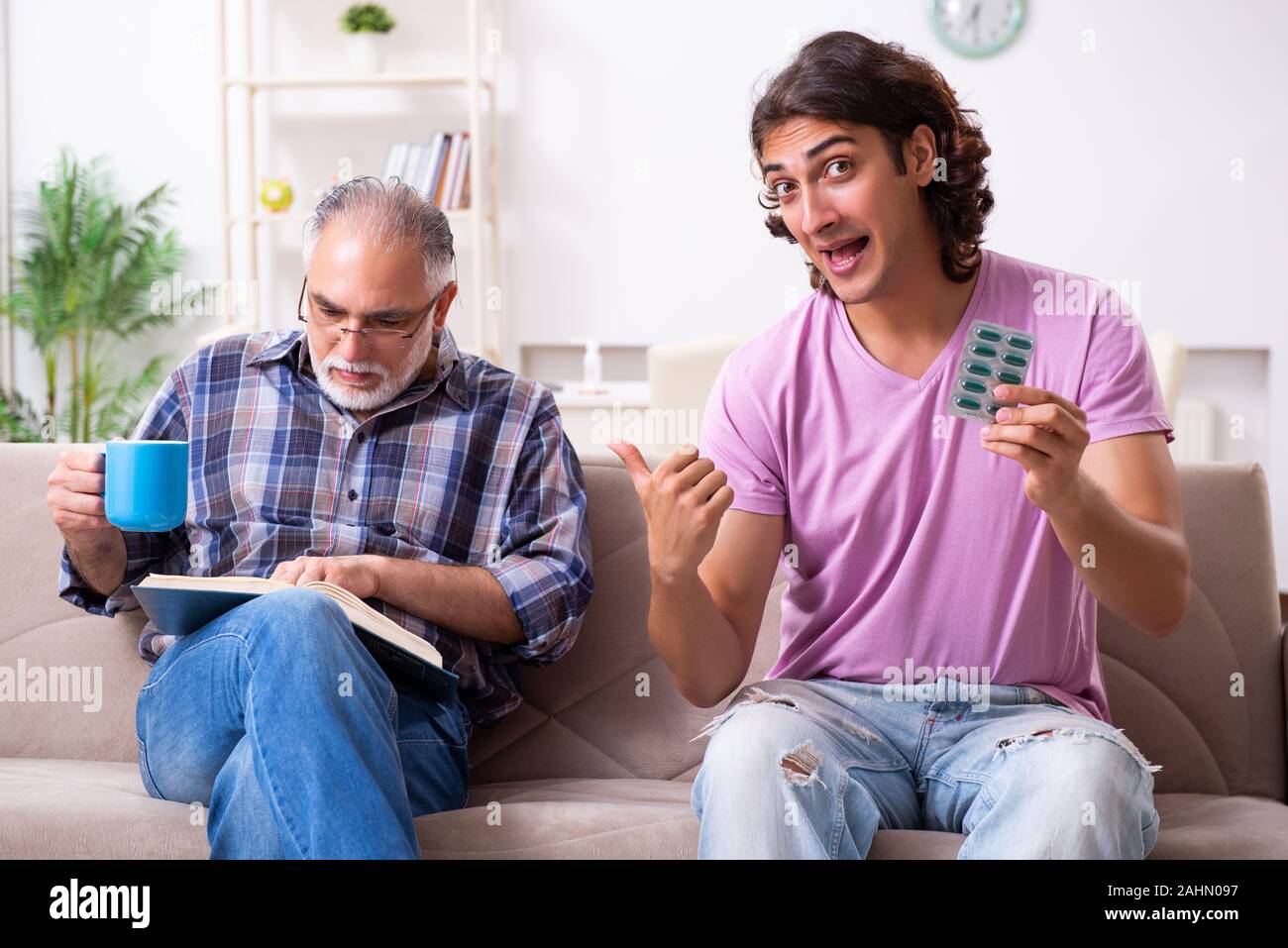 The young student and his old grandpa at home Stock Photo - Alamy