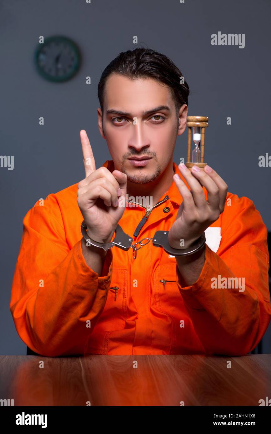 The young convict man sitting in dark room Stock Photo - Alamy